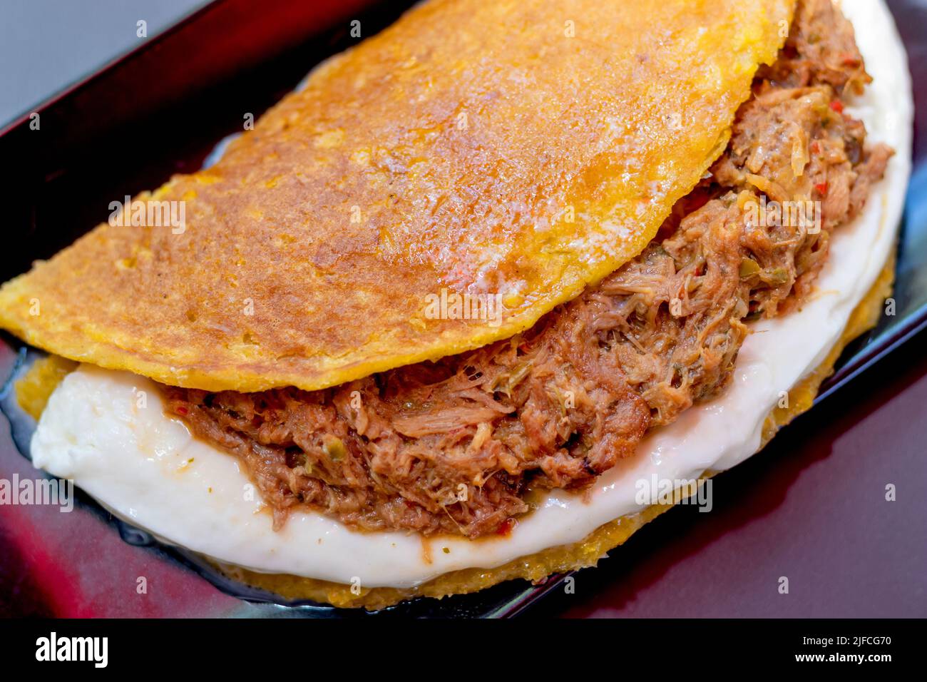 Cachapa with pulled meat, corn tortilla with cheese, meat and butter ...
