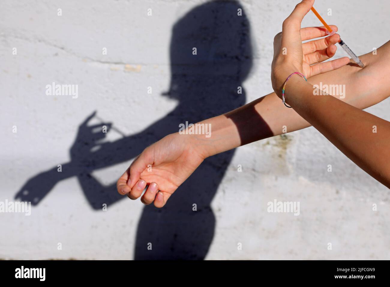 awesome scene of a young drug addict during injection with syringe and ...