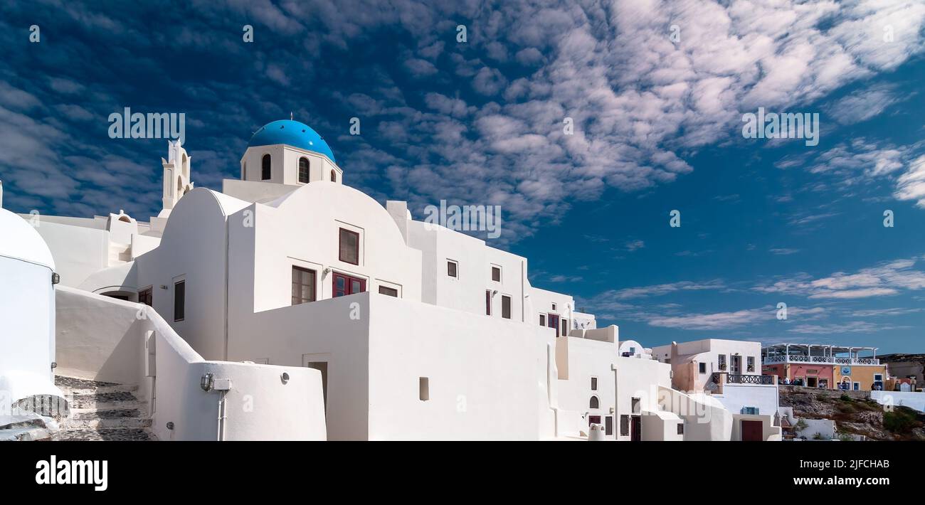 The cloudy blue sky over white Santorini view church Oia on a sunny day ...