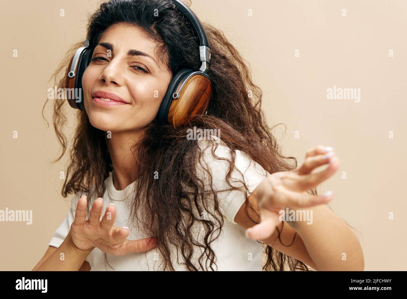 TALENT CONCEPT. Overjoyed Latin lady with headphones posing isolated ...