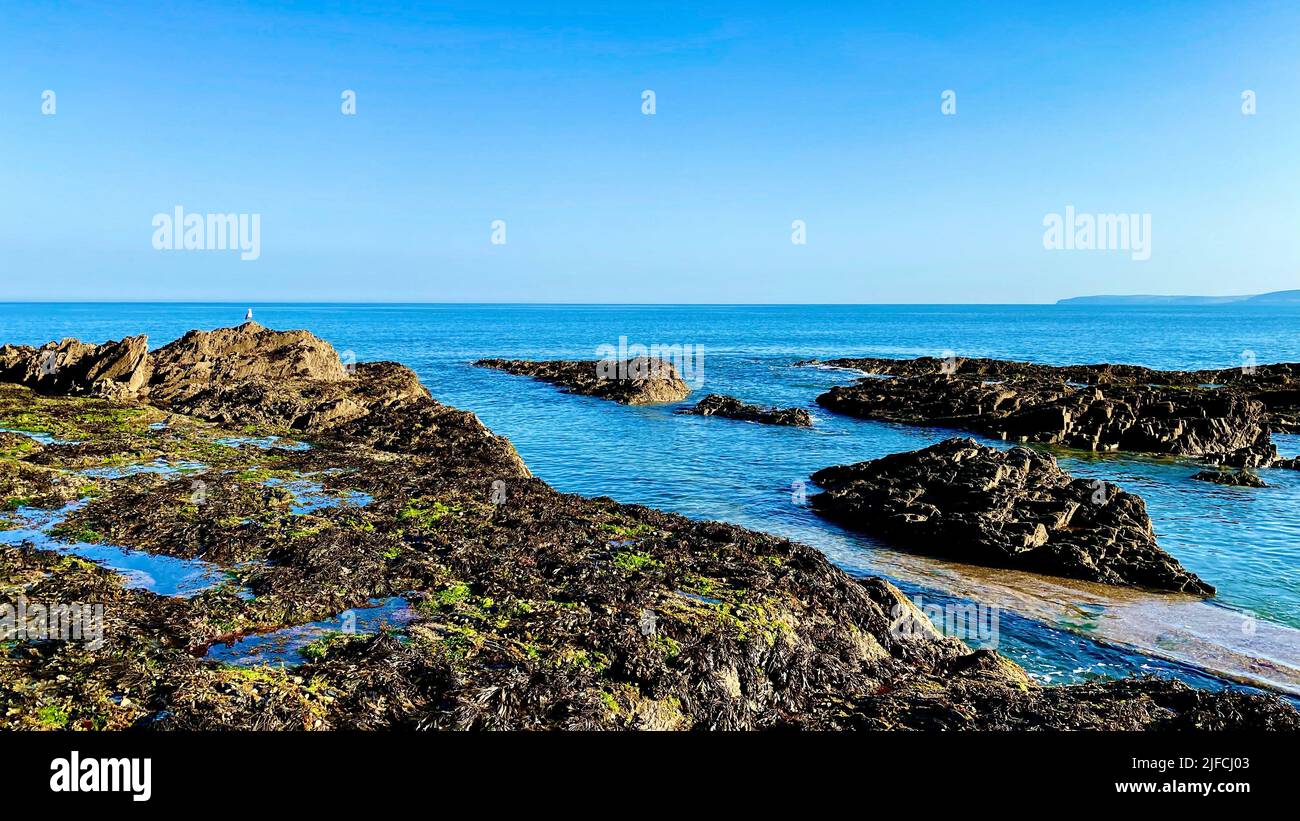 A scenic blue ocean with rock islets under a clear sky Stock Photo - Alamy