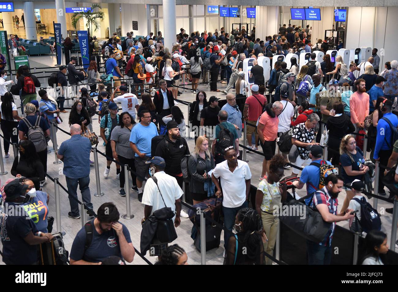 Travelers make their way through a TSA screening line at Orlando ...