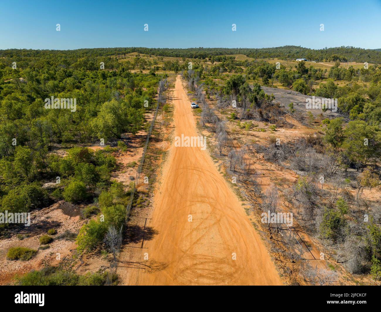 Drone coming into land on a red dirt road amongst the Australian scrub ...