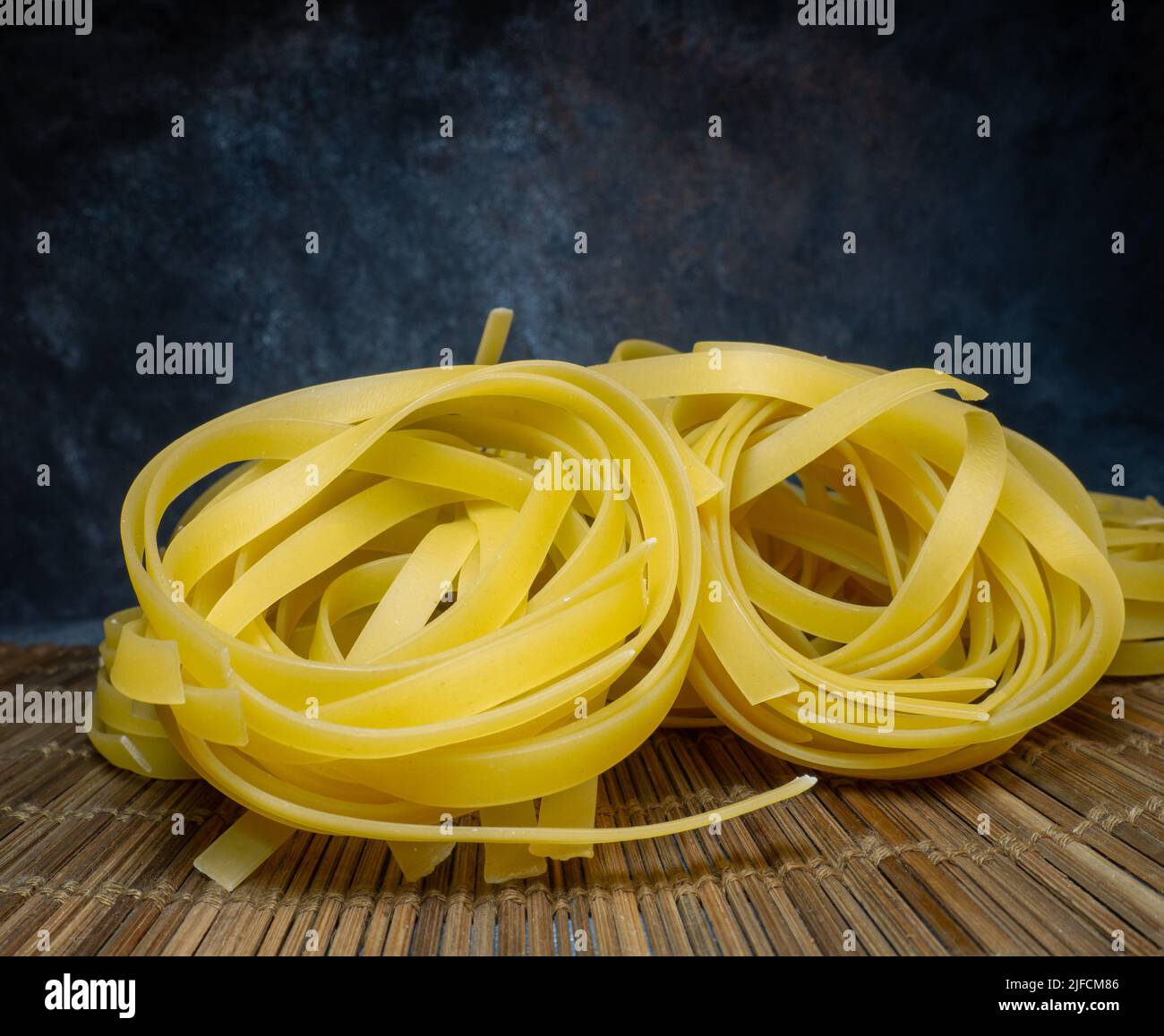 Pasta nests on a wicker background. Type of noodle. Unprepared product ...