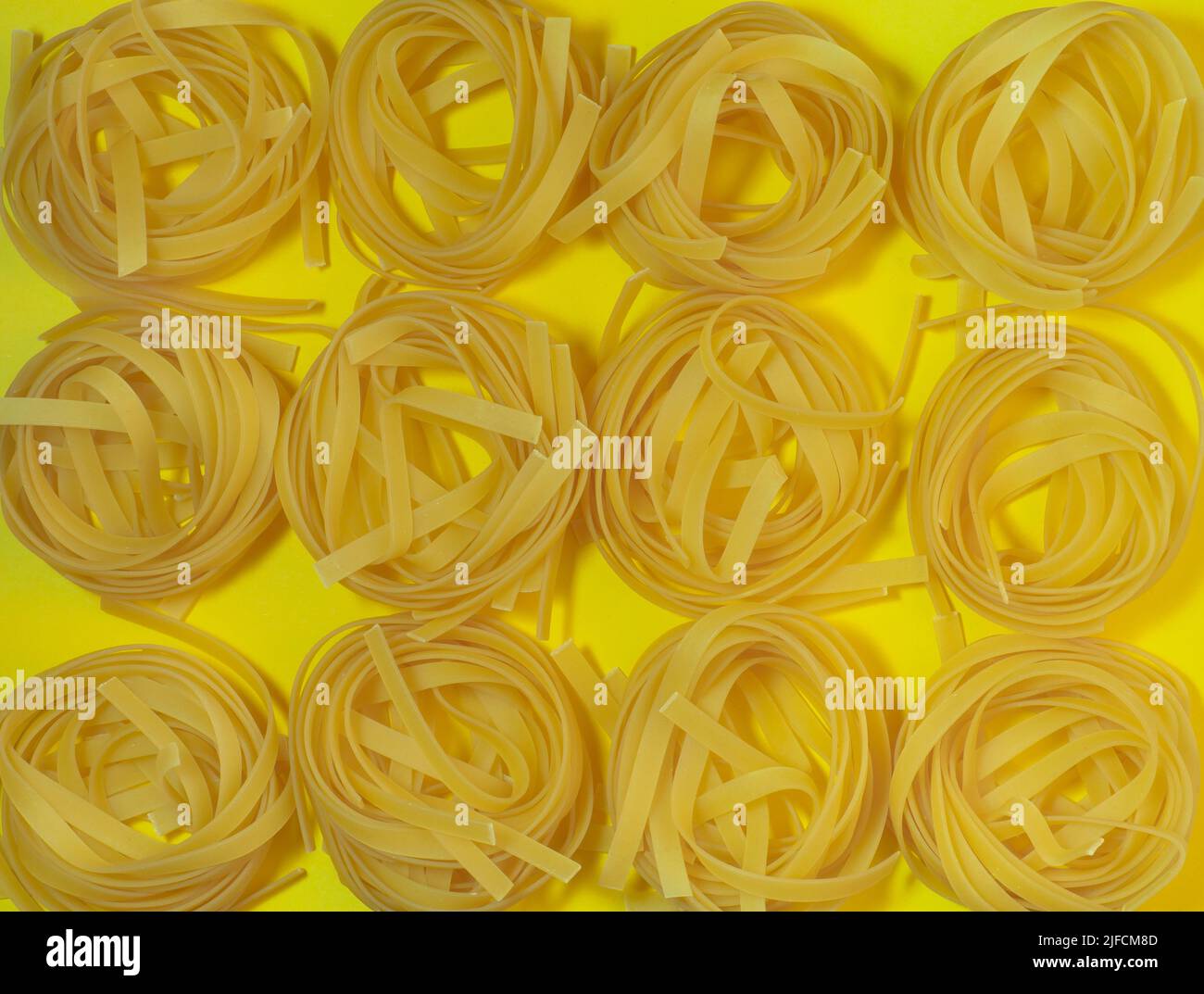Pasta nest on a yellow background. Noodle type. Culinary background ...