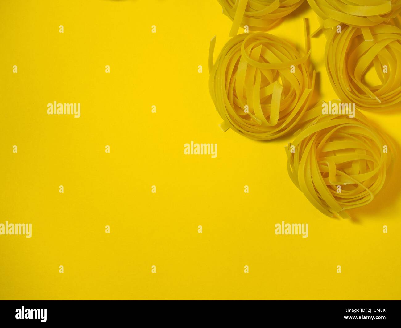 Pasta nest on a yellow background. Noodle type. Culinary background ...