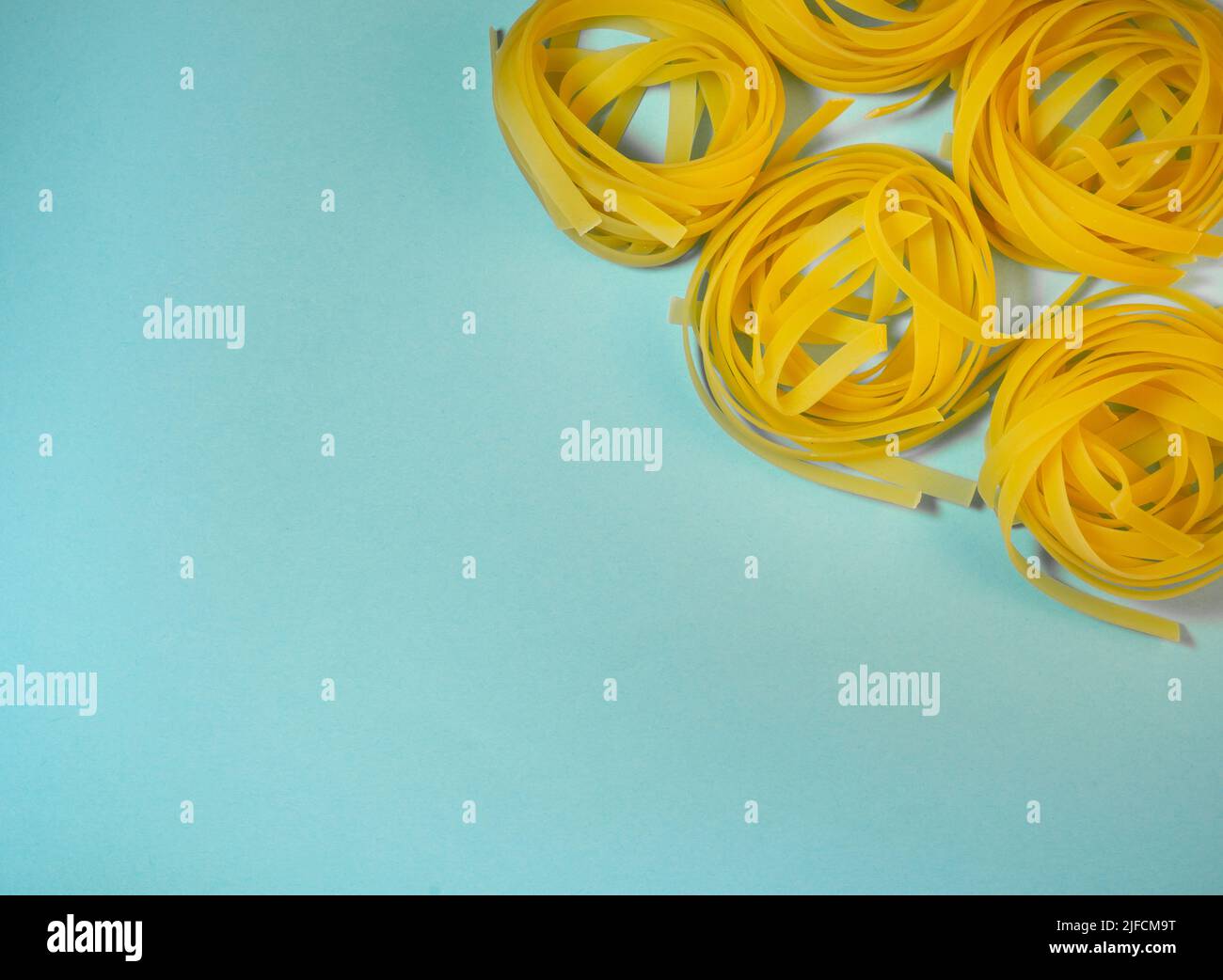 Pasta nests on a blue background. Noodle type. Culinary background ...