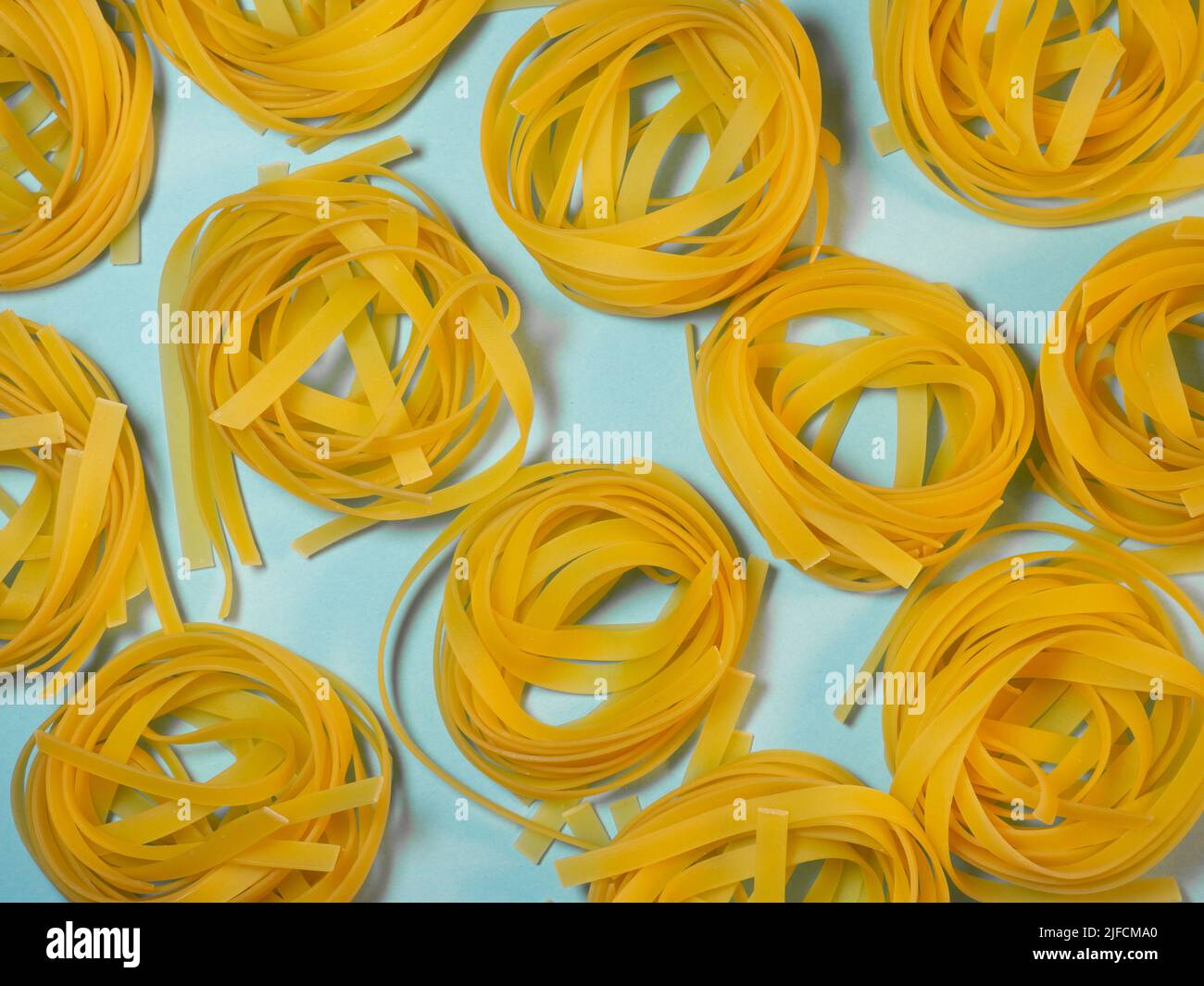 Pasta nests on a blue background. Noodle type. Culinary background ...