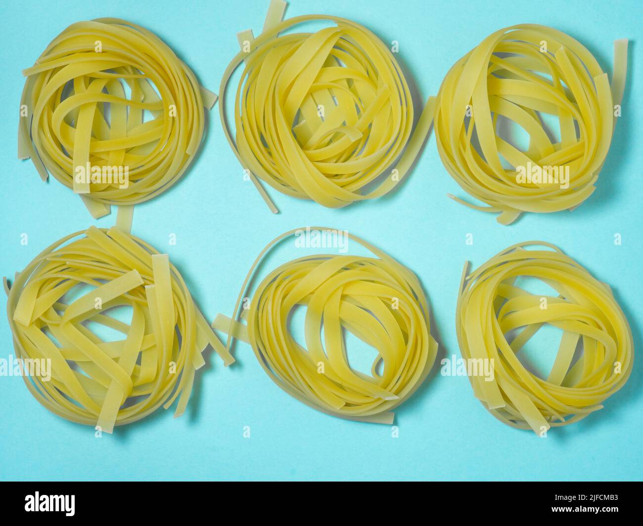 Pasta nests on a blue background. Noodle type. Culinary background ...