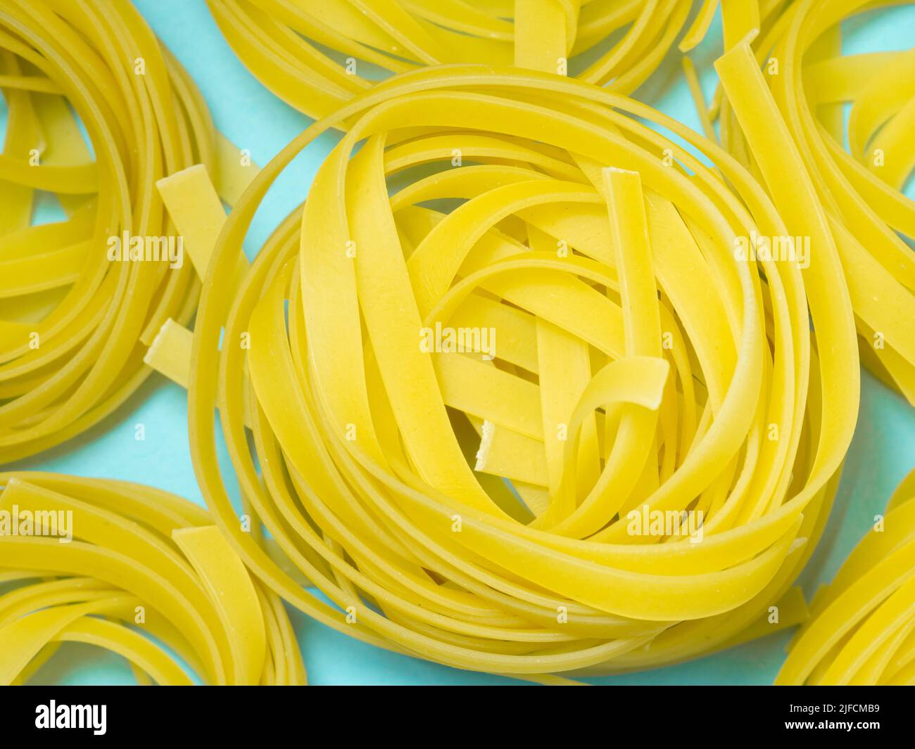 Pasta nests on a blue background. Noodle type. Culinary background ...