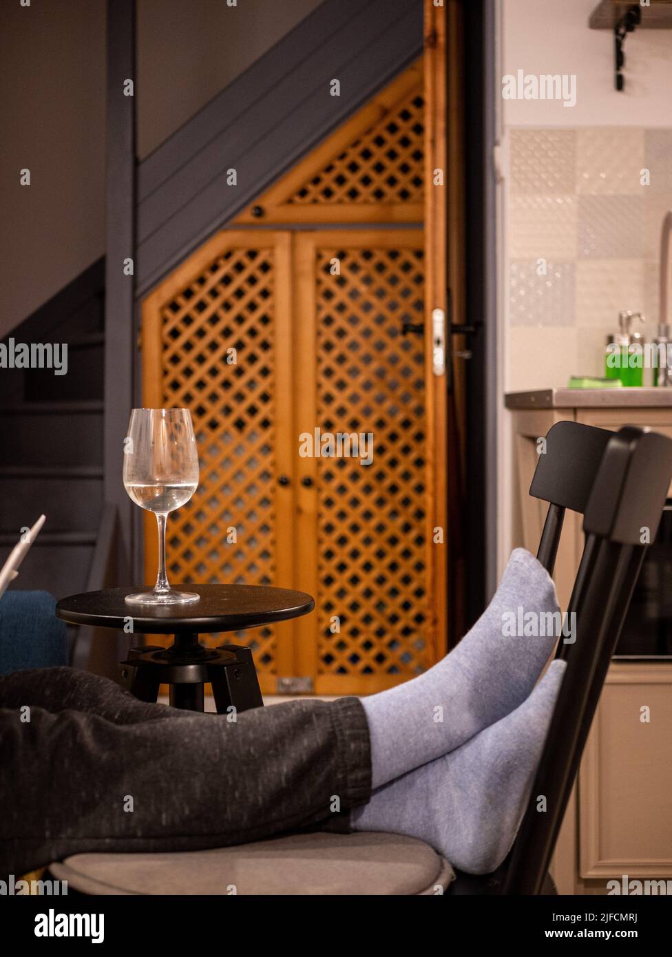 A cozy room with a dark staircase and closet, with a person's feet on a ...