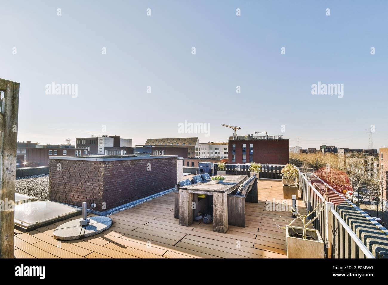 Wooden tables and chairs on the roof of an apartment building ...