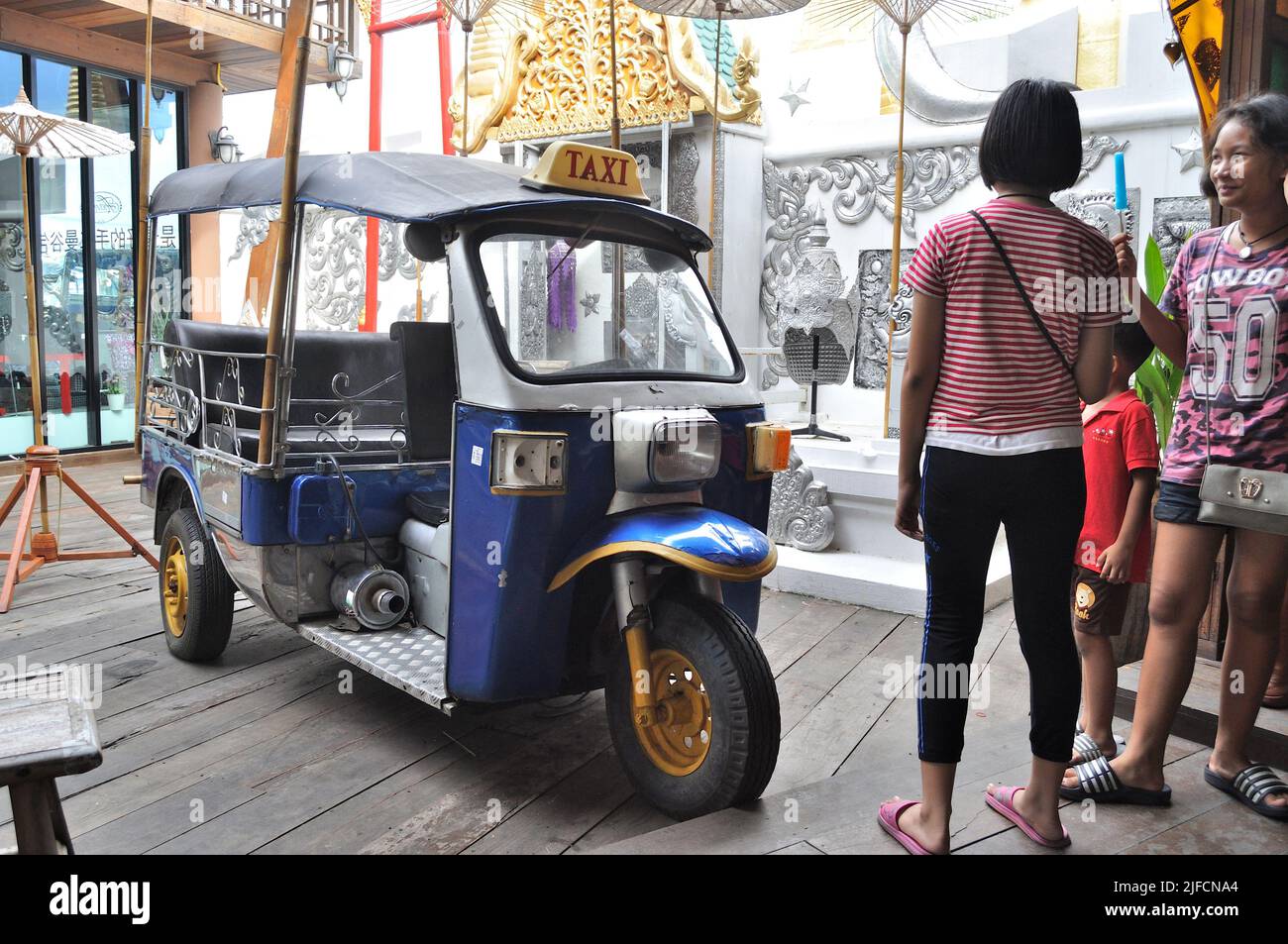 Asian woman standing next to a tuk tuk vehicle. Pattaya, Thailand Stock ...