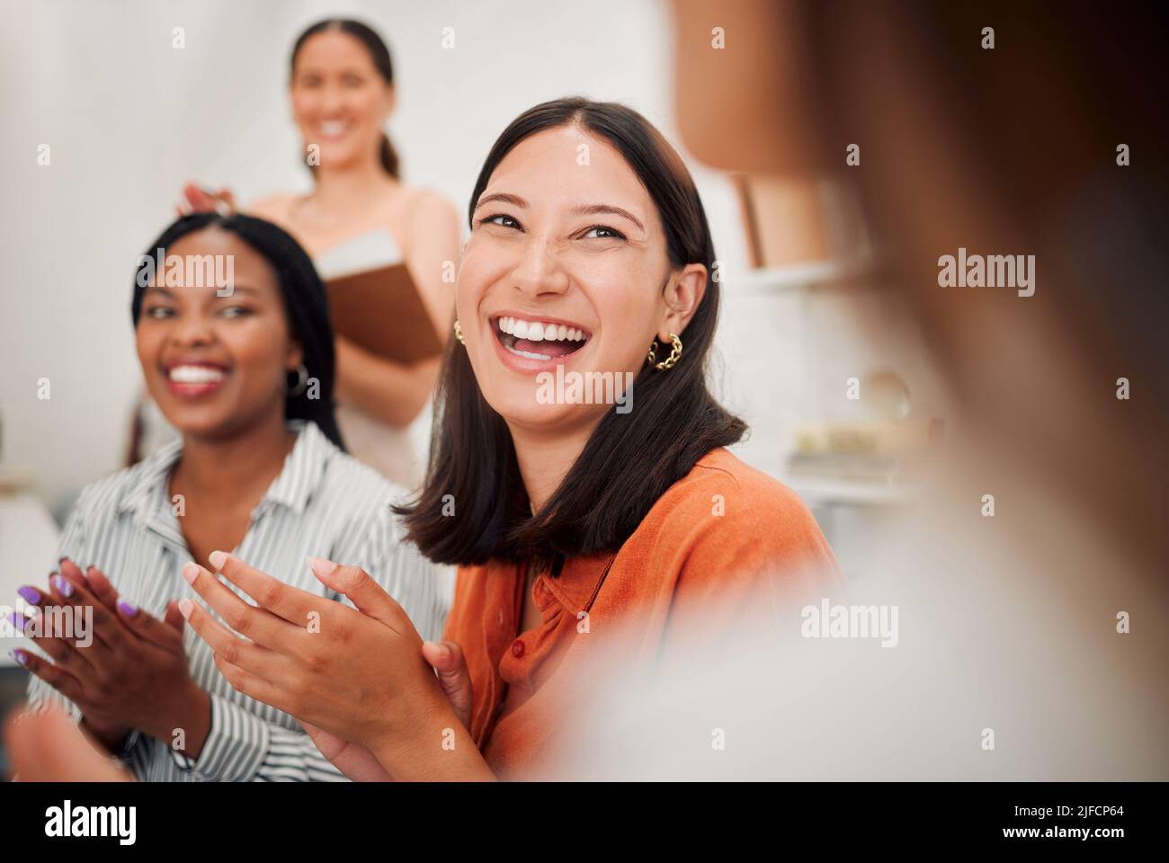 Happy young hispanic businesswoman clapping hands during a meeting in ...
