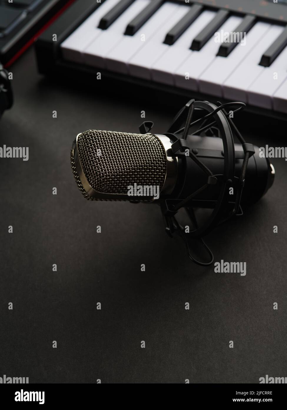 Studio microphone and synthesizer, midi keyboard on a gray background ...
