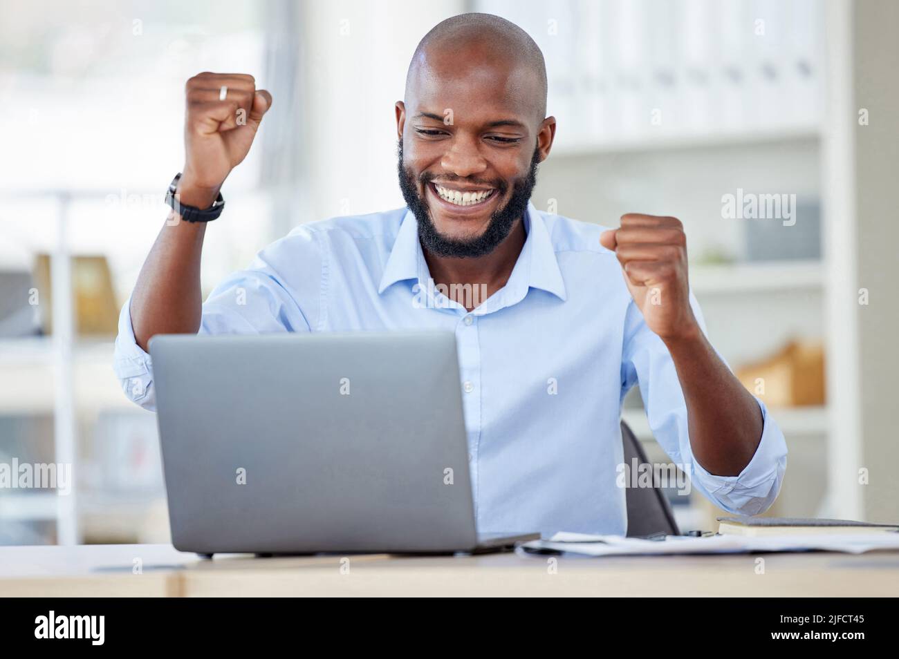 Young happy african american businessman cheering with joy and working ...