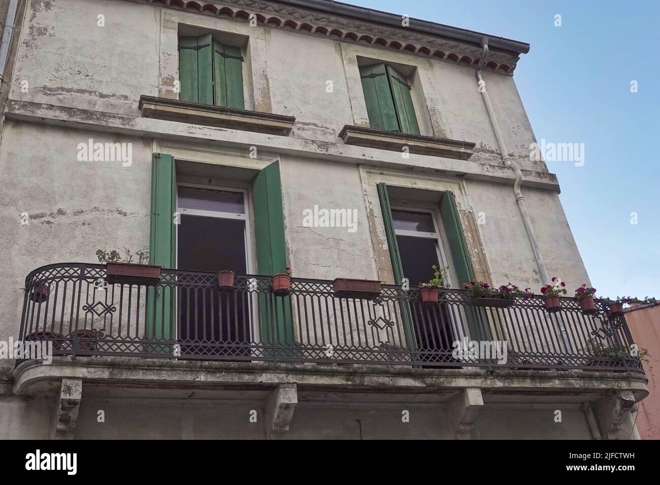 A view of an old apartment building facade with windows and a big ...