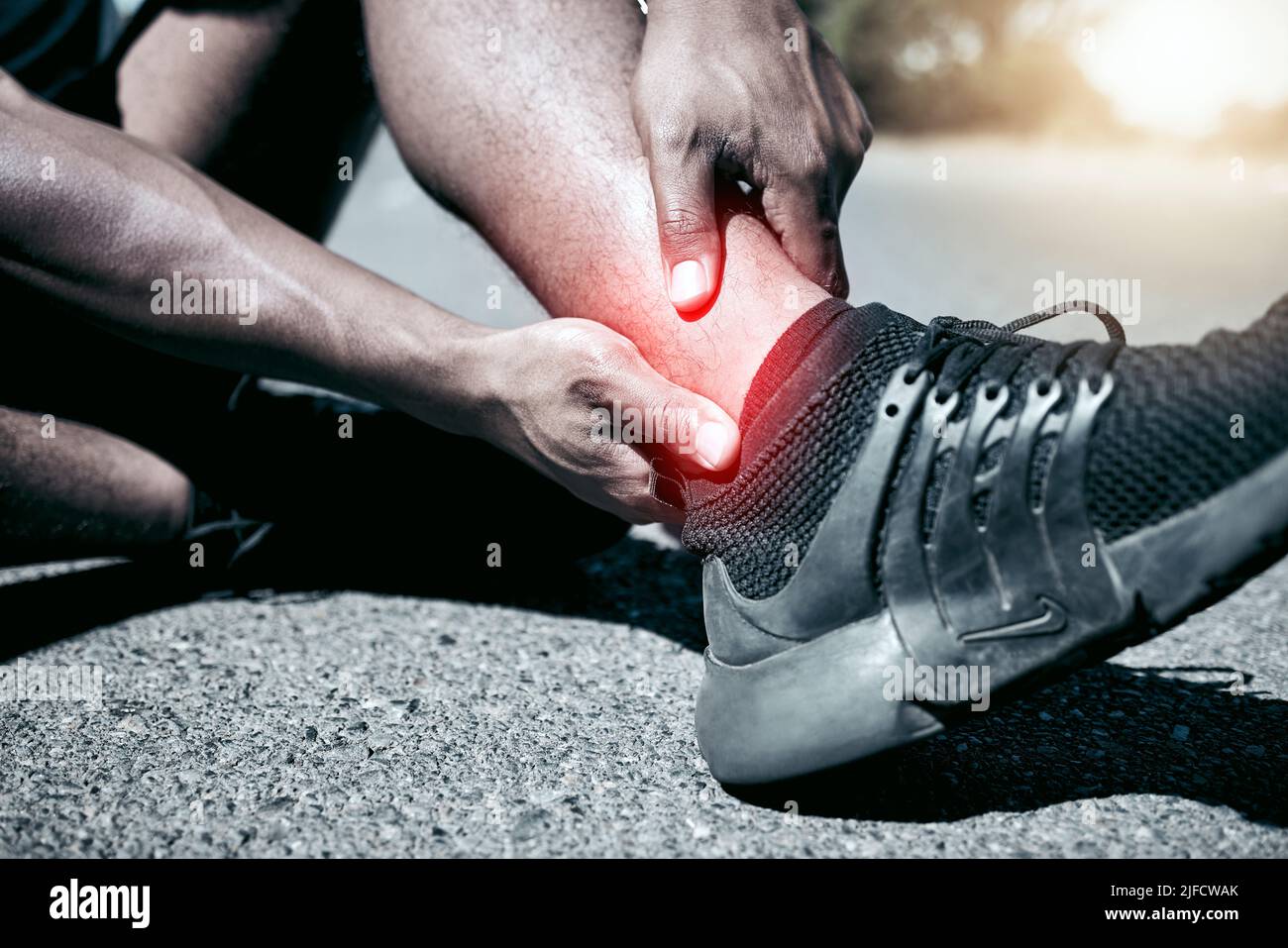Closeup fit mixed race man holding his ankle in pain while exercising ...