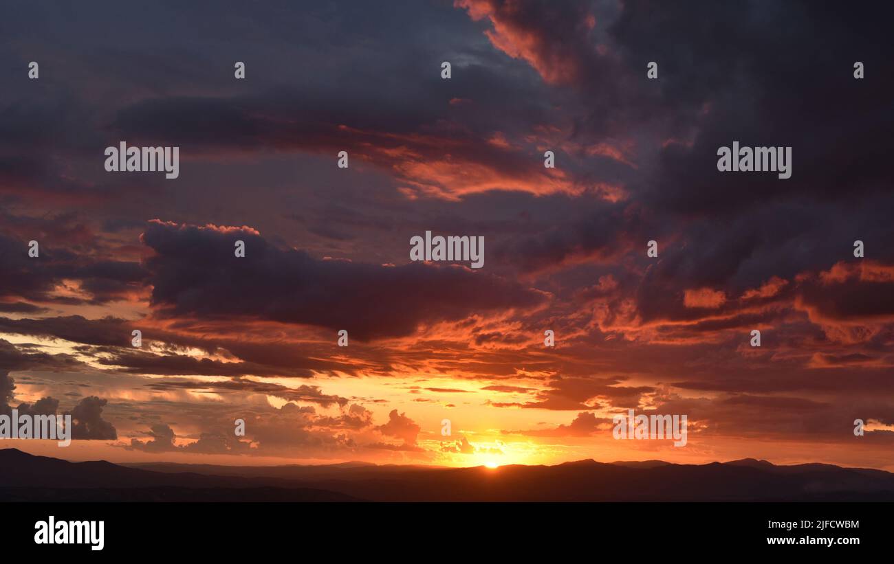 Sunset of a blazing red with clouds, a summer day in the Tuscan ...