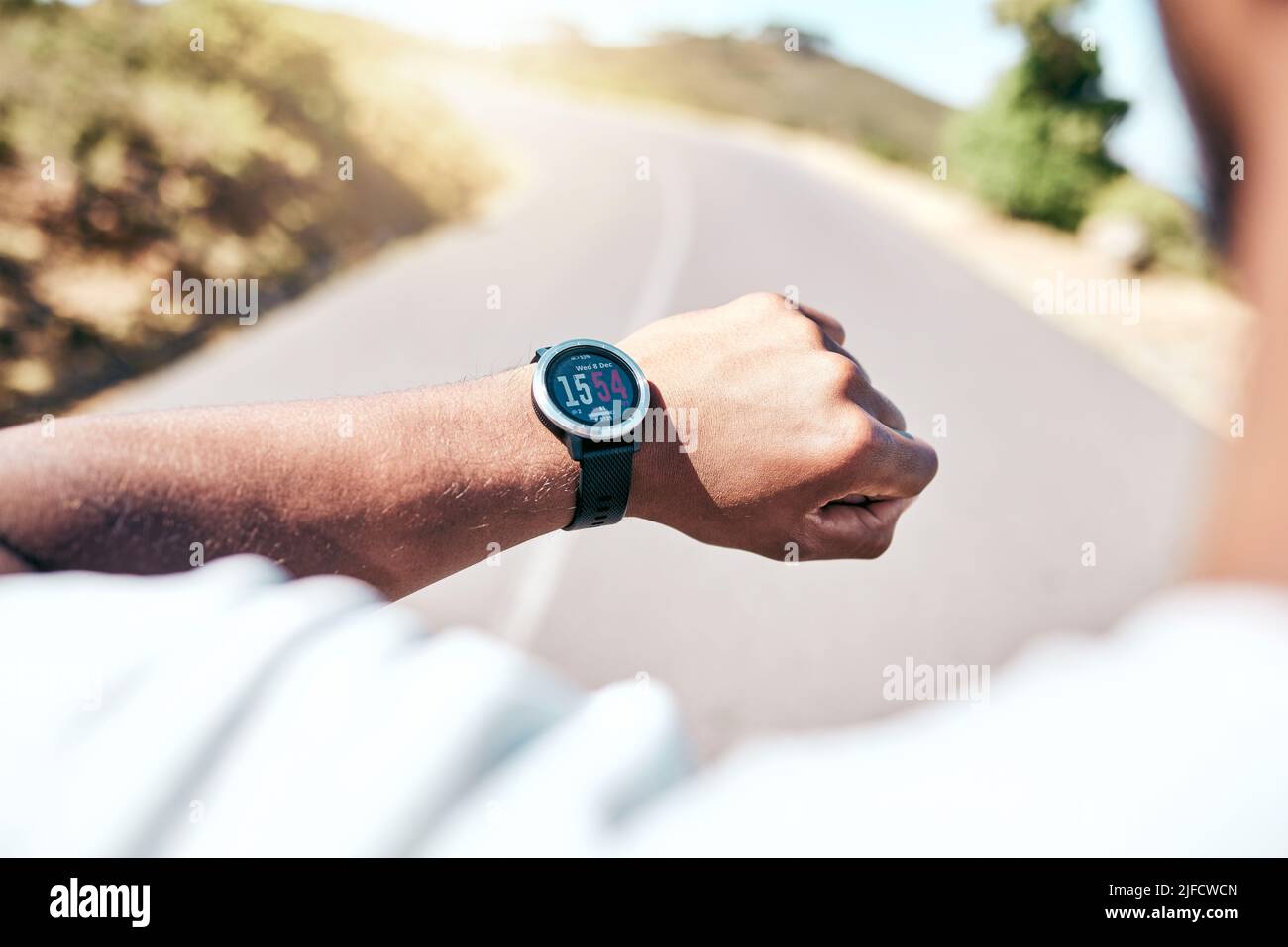 Fit man timing himself during his run outdoors. Ethnic man checking his ...