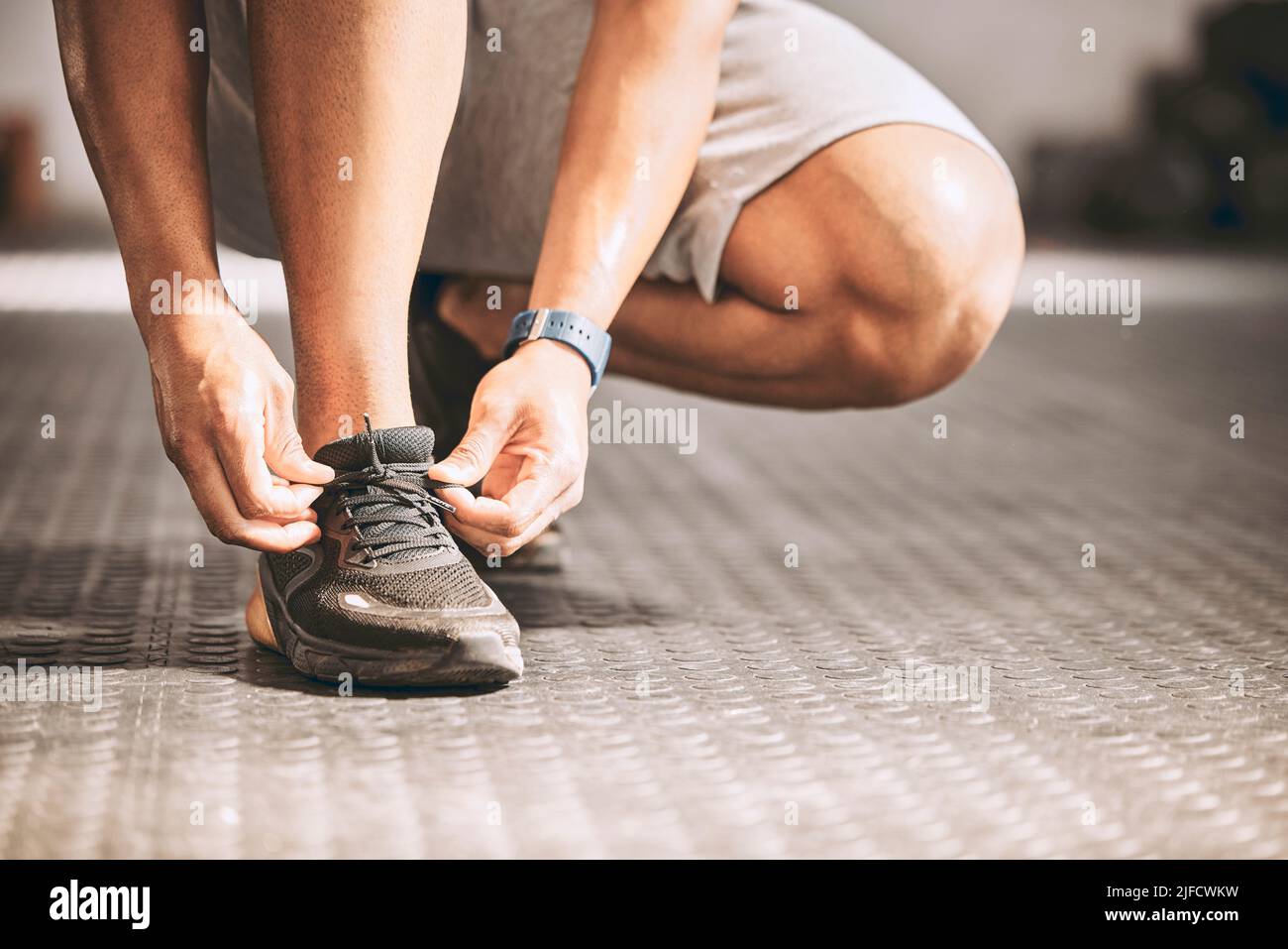 Hands of a fit man tying laces. Bodybuilder tying his shoe laces ...