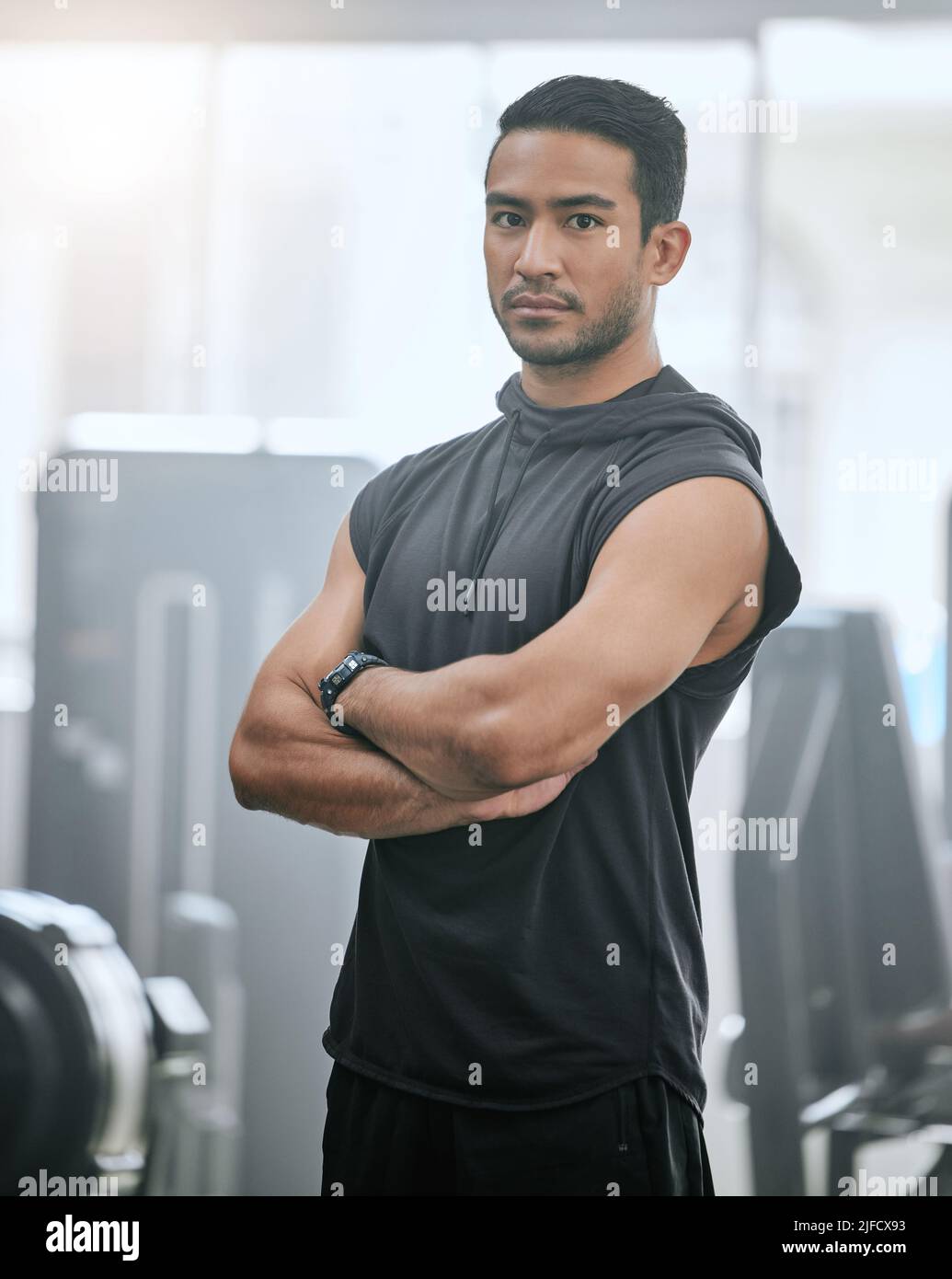 Portrait of one serious asian trainer alone in gym. Handsome focused ...
