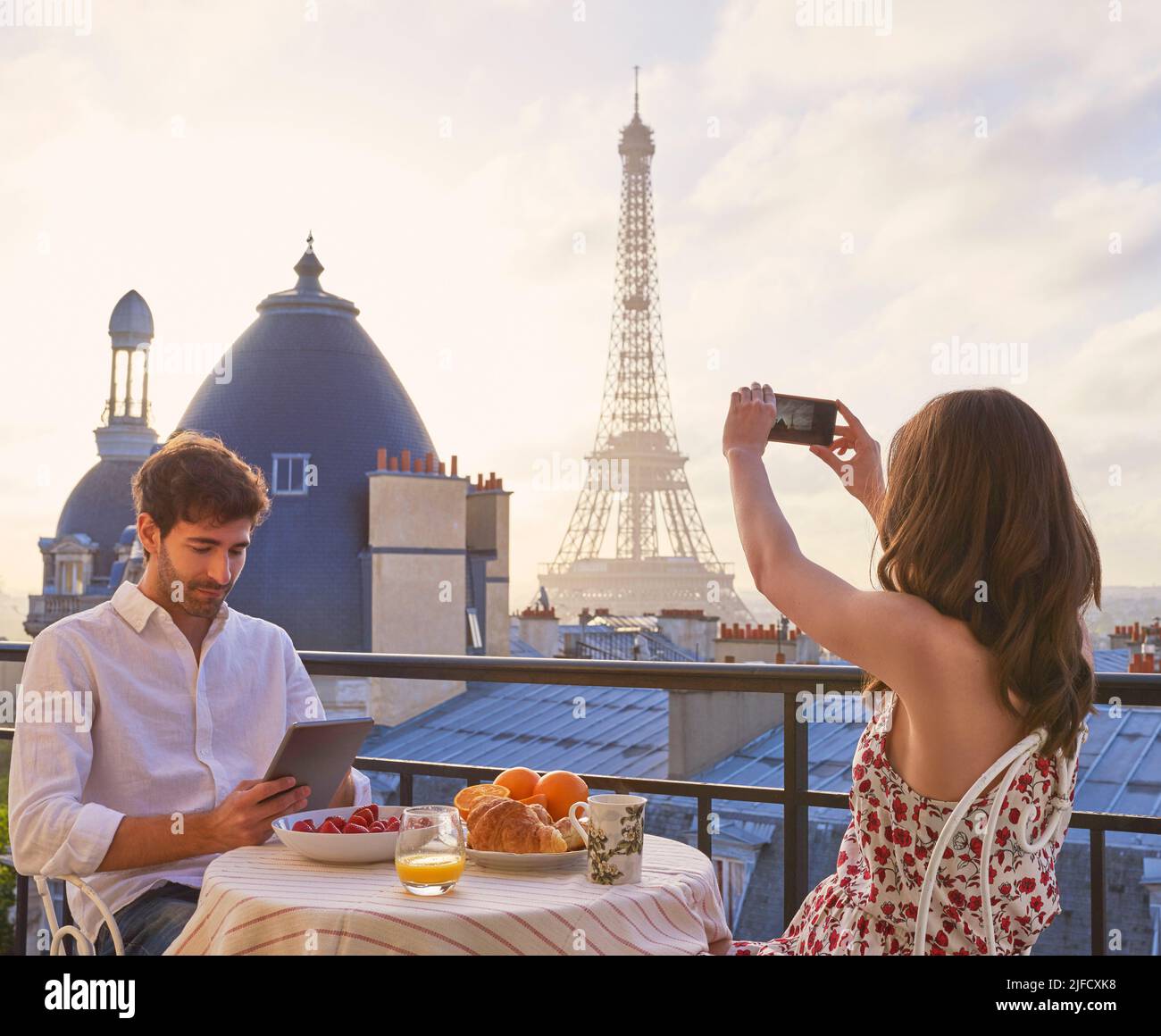 A view worth waking up to. Shot of a young couple having breakfast on ...