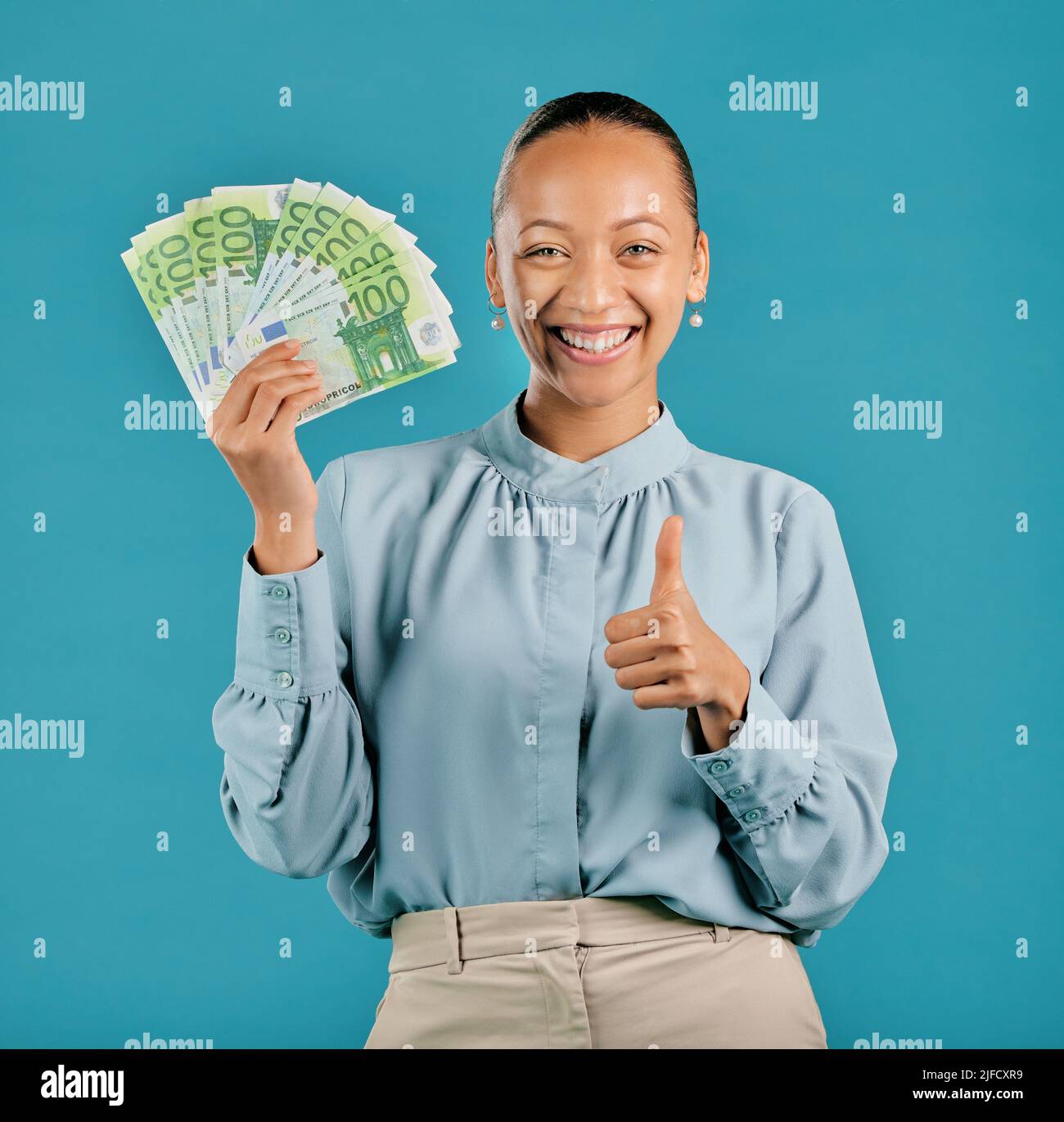 . Woman showing thumbs up whole holding fanned out bank notes Stock ...