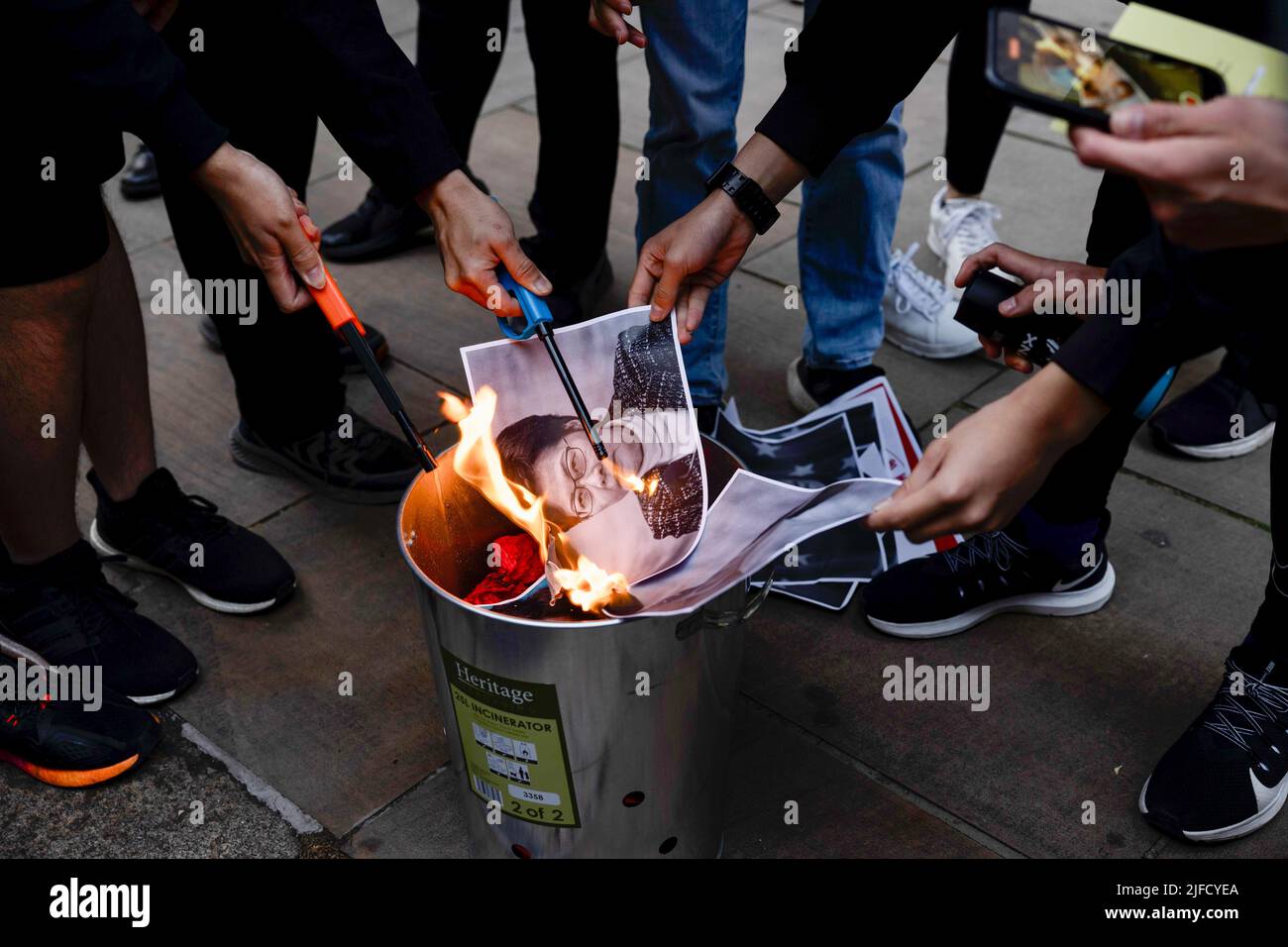 Protesters are seen burning the portrait of Xi Jinping at the rally ...