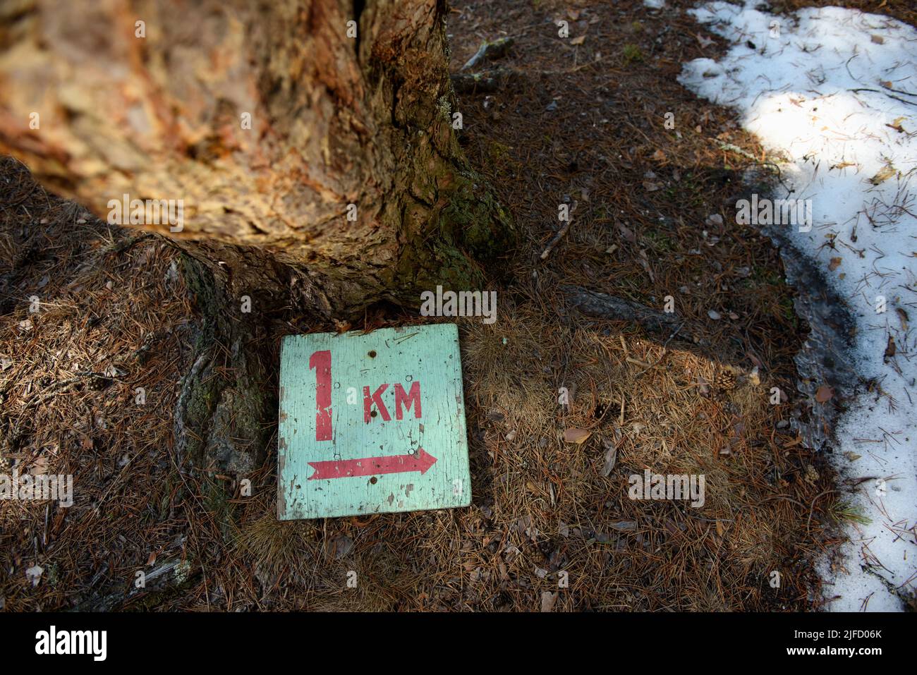 A sign indicating the length of the tourist route 1 kilometer lying on ...