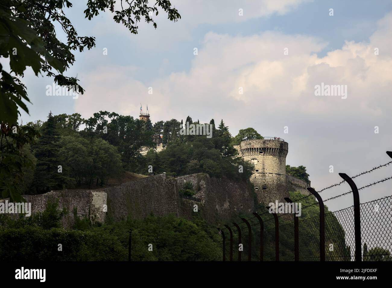 Old fortification on a cliff in a forest seen from the distance behind ...