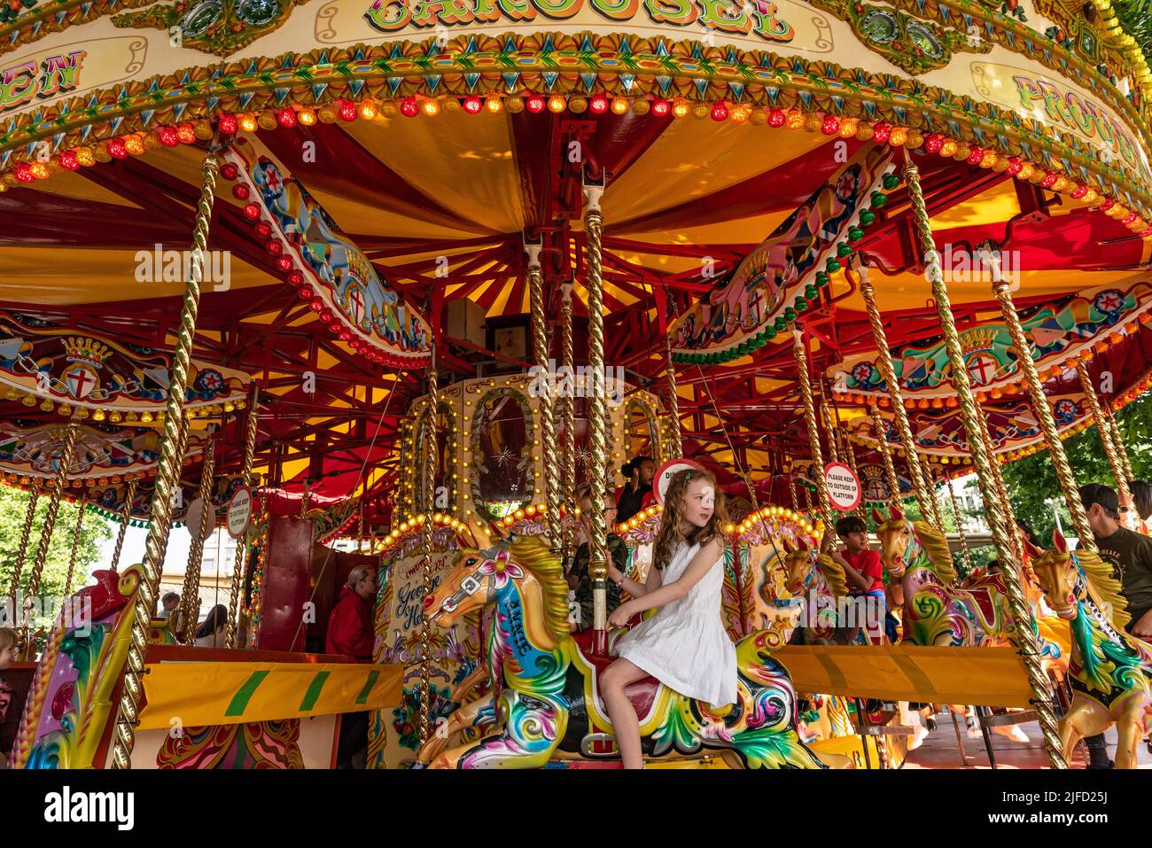 London, UK. 28th June, 2022. A child enjoys a funfair carousel ride at ...