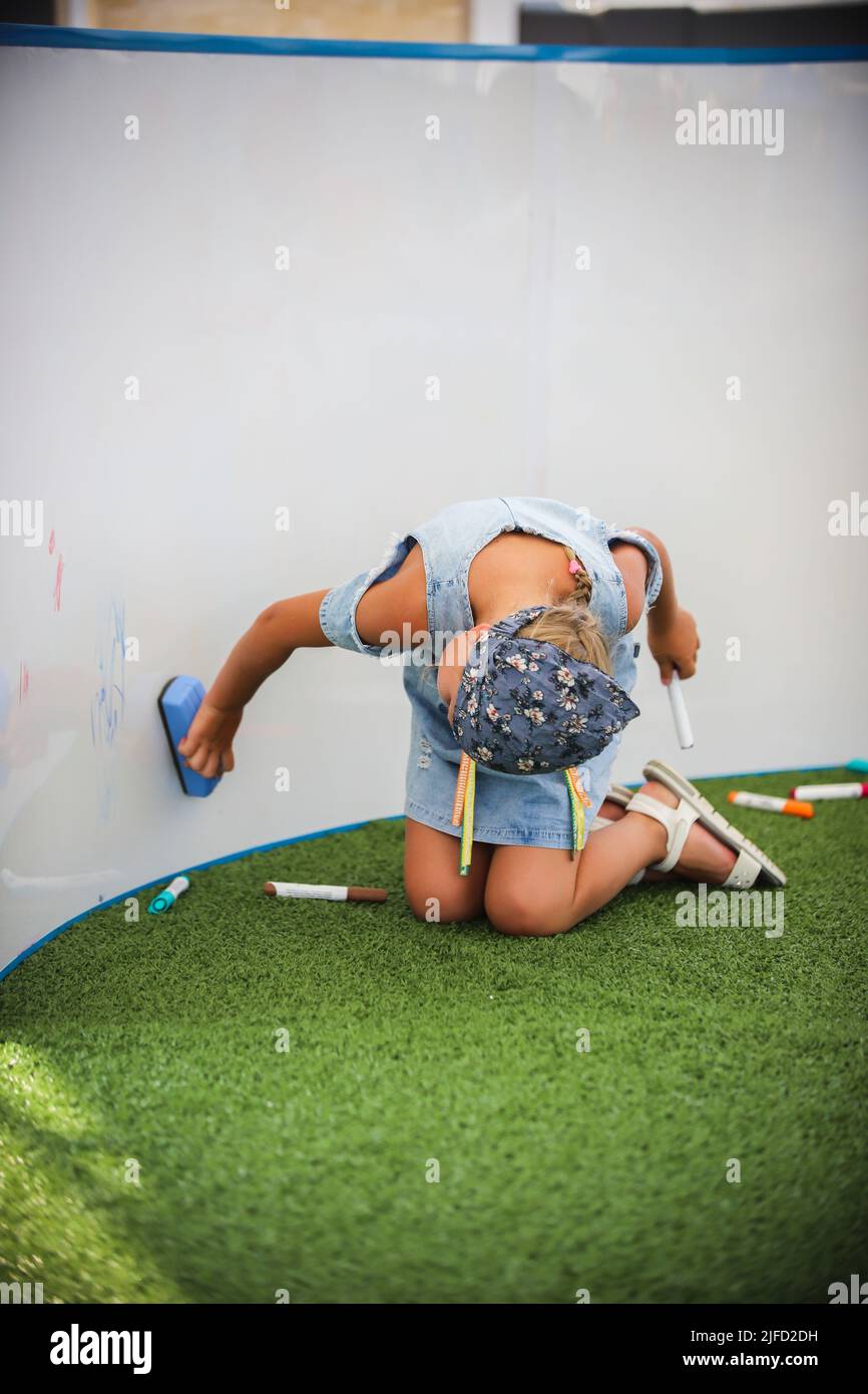 A little girl in panama erases her drawing from the wall Stock Photo ...
