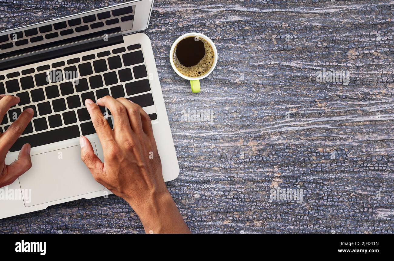 Hand working laptop comuter with cup of coffee on wooden desk. Hand ...