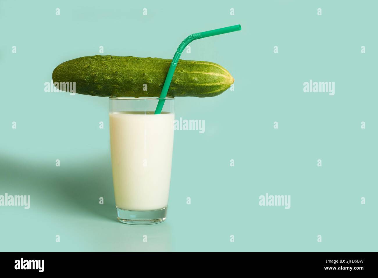 Natural laxative. Glass with milk, plastic tube and cucumber Stock ...