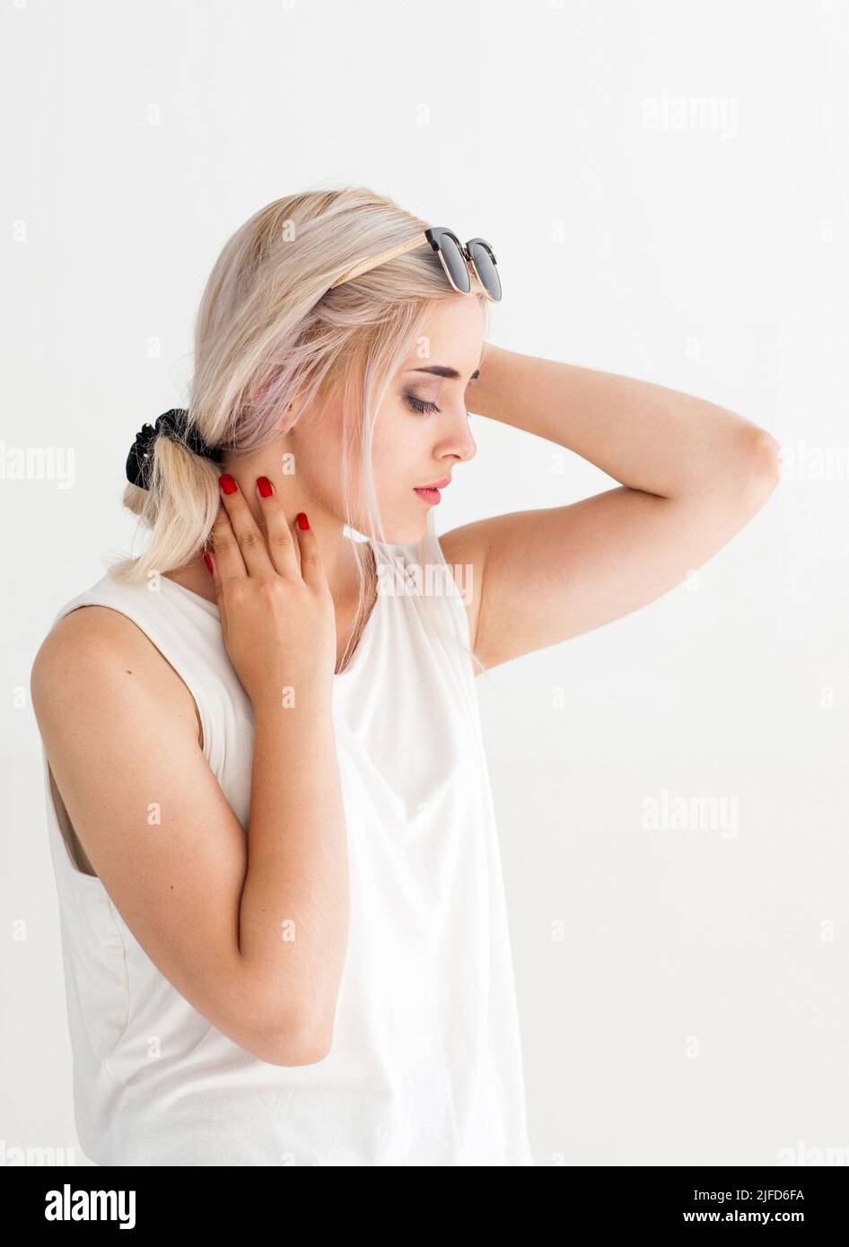 Beautiful sensitive woman touching her neck Stock Photo - Alamy