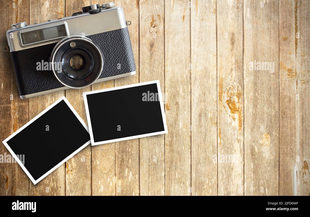 Vintage film camera and two blank photo frames on wooden table. Top ...