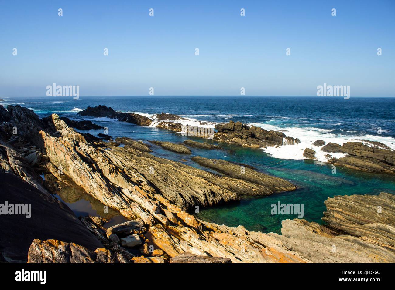 Tilted and Jagged rocks protecting the calm rock pools from the ocean ...