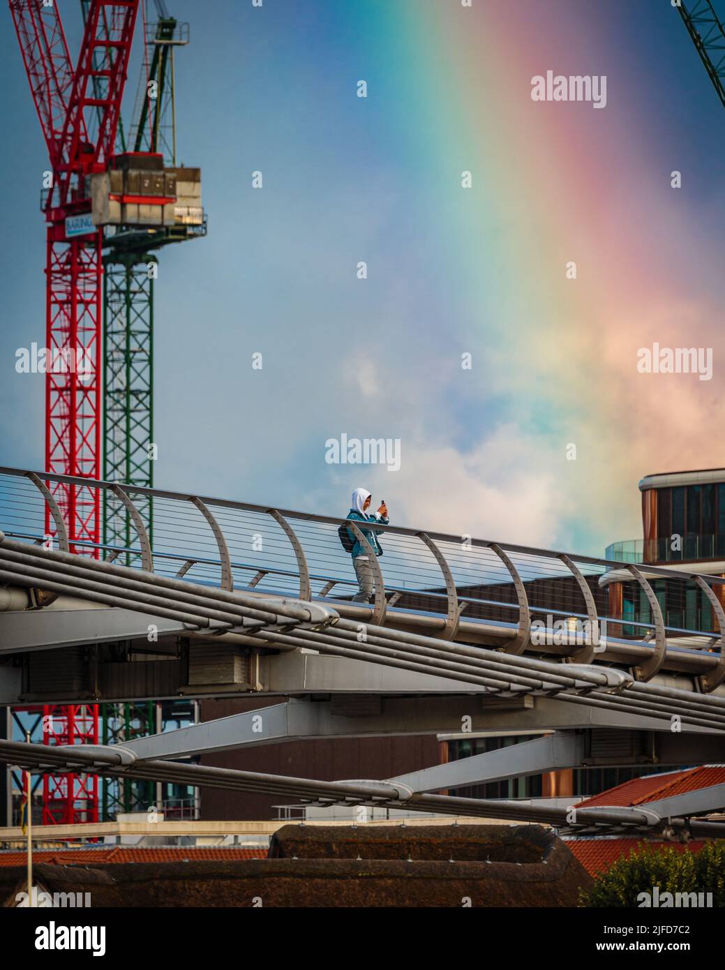 A tourist takes a photograph of the beautiful colorful rainbow over ...