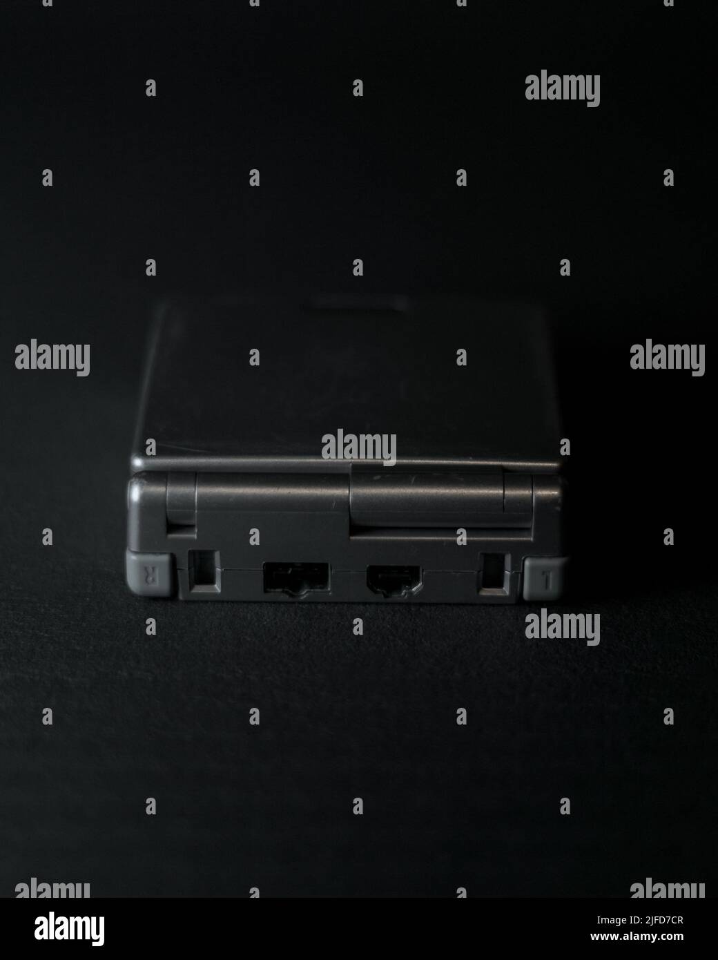 A black Gameboy advance on the table isolated with black background ...