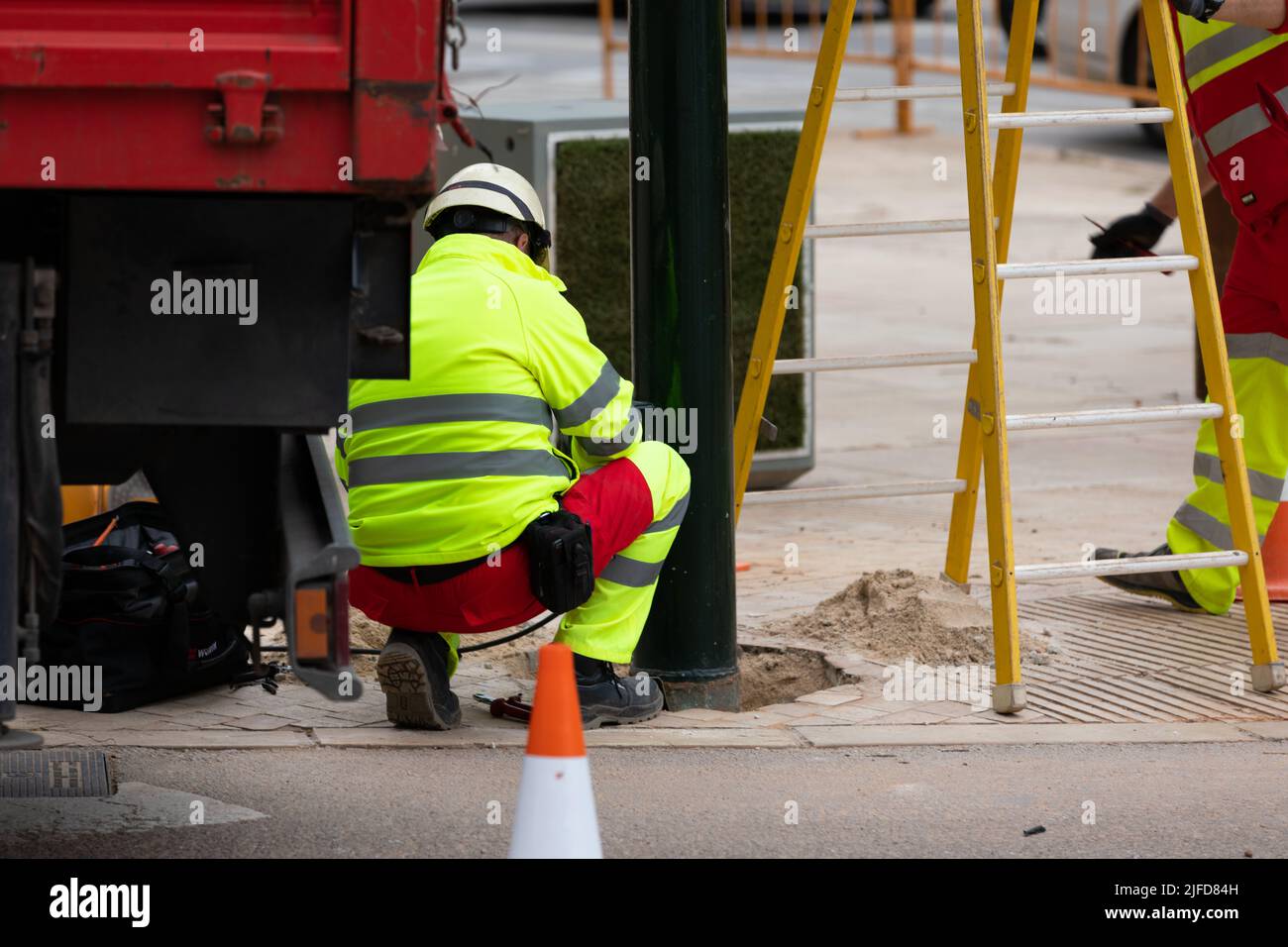 Two electrician worker fixing a traffic light in city street Stock ...
