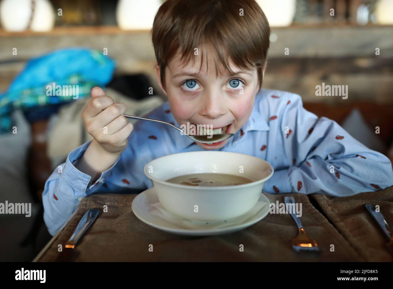 Boy eating dumplings with broth in restaurant Stock Photo - Alamy