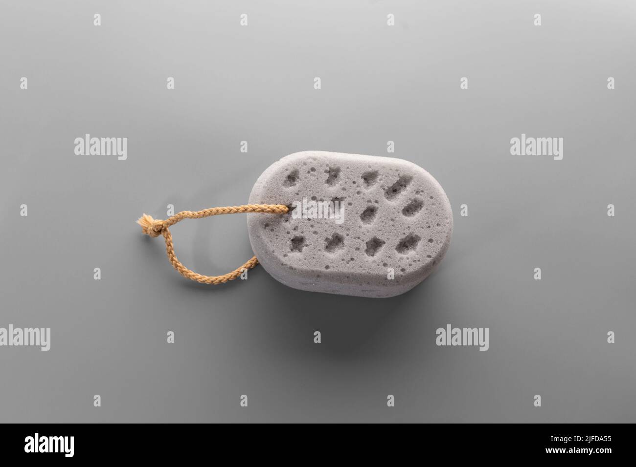 grey sponge on grey background, monochrome concept, exfoliating shower ...