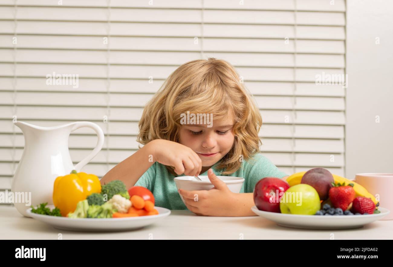 Schoolchild eating breakfast before school. Portrait of little teen ...