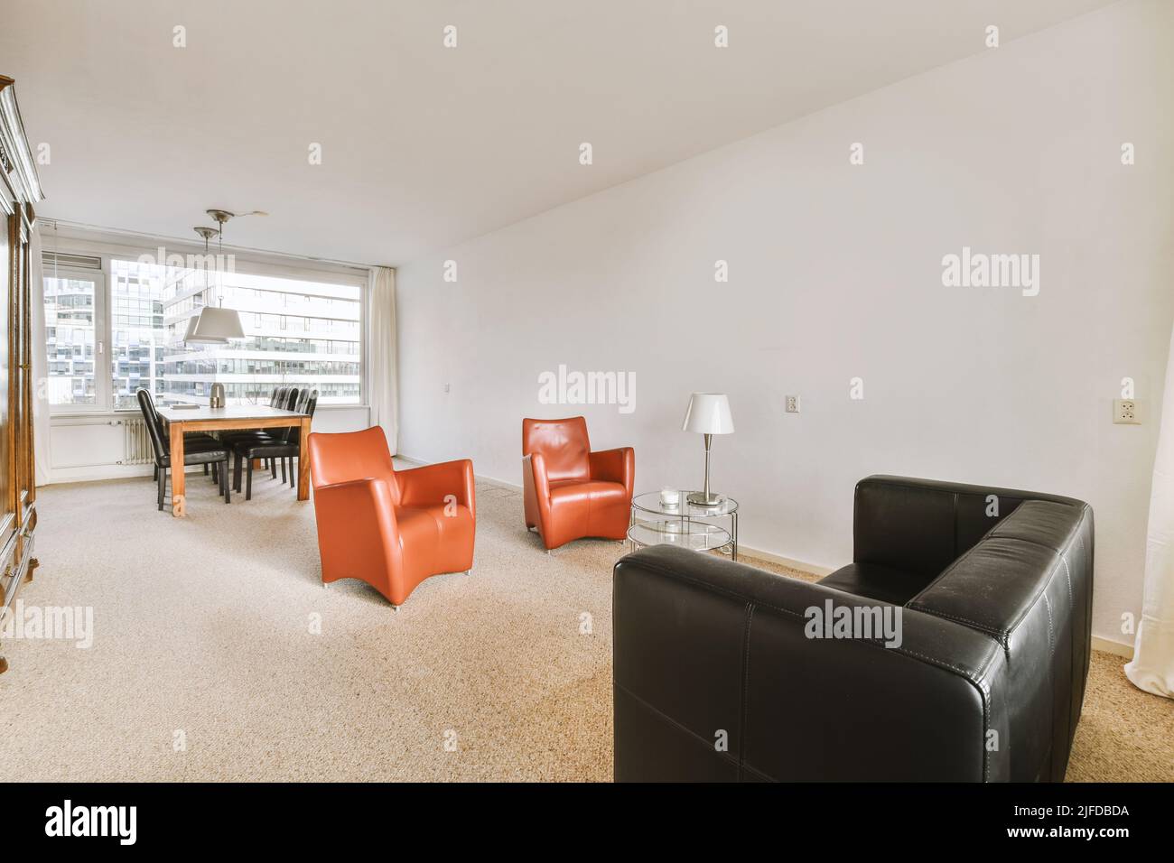 Comfortable chairs and wooden table placed under stylish lamps against ...