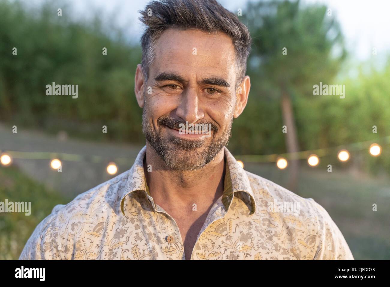 Good looking man portrait posing smiling in nature background in summer ...