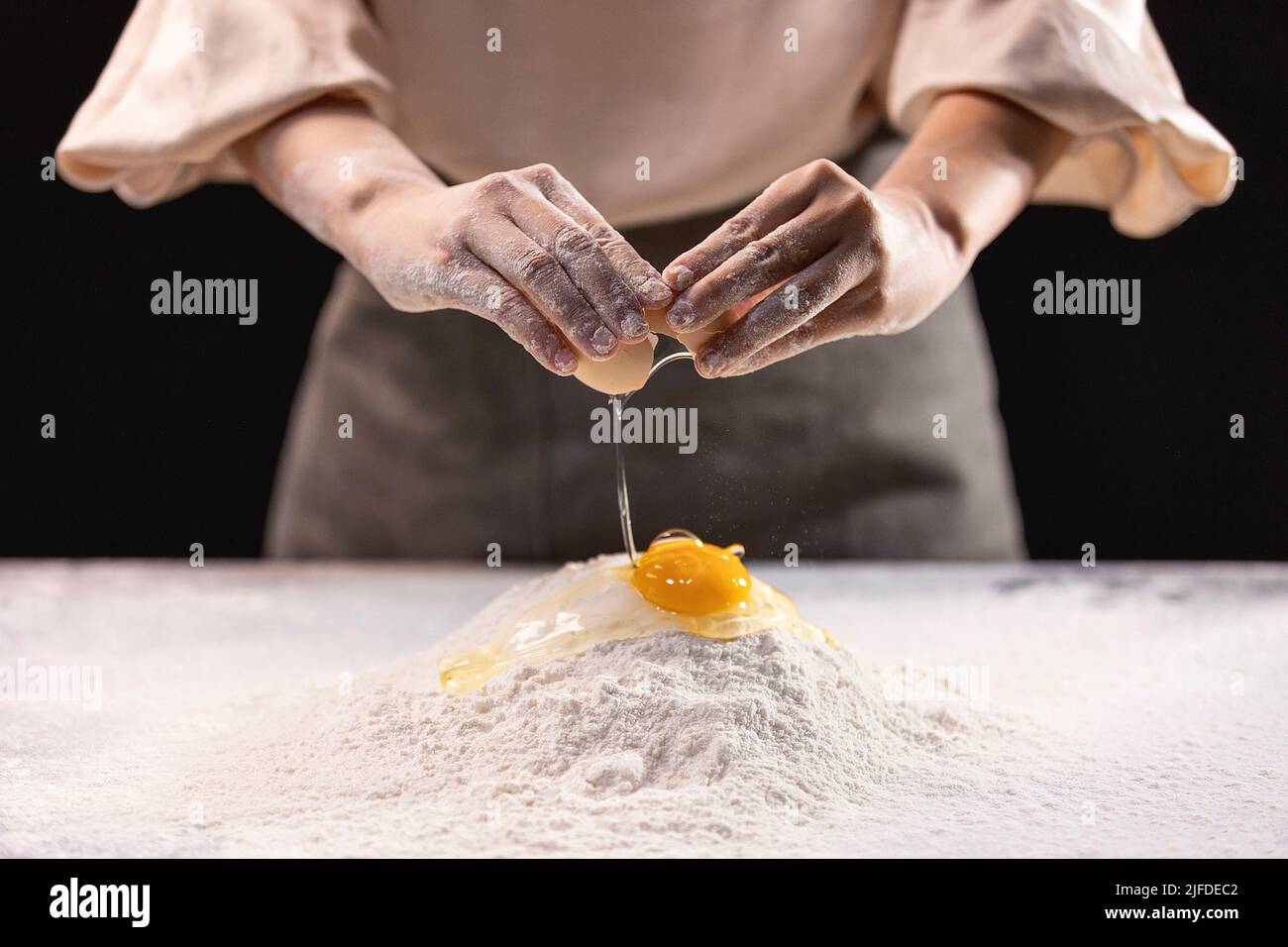Adding eggs to flour, the traditional Chinese pasta wheaten food making ...