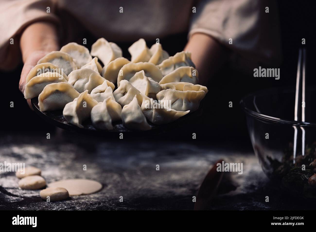 Showing a plate of wrapped dumplings, the process of making traditional ...