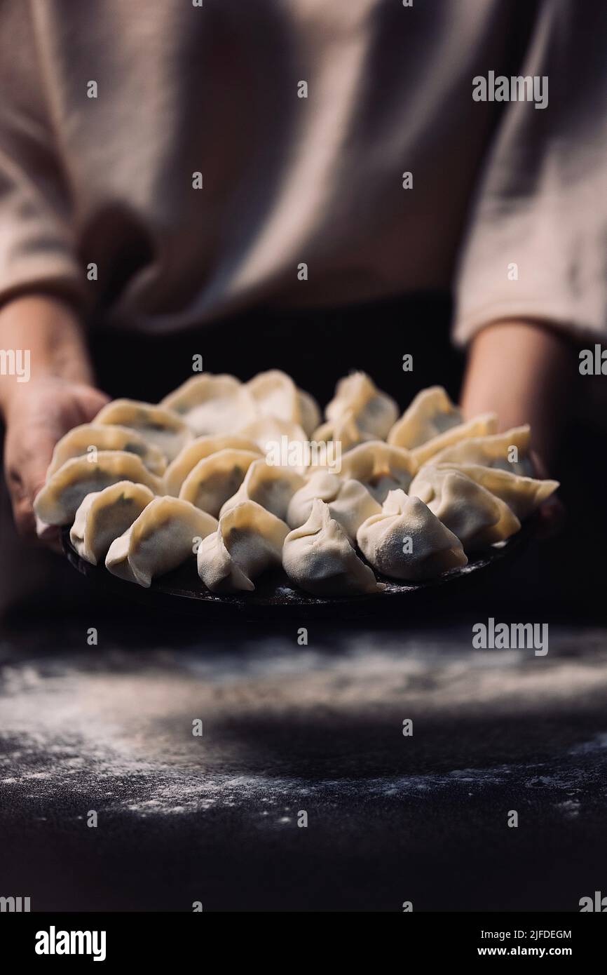 Showing a plate of wrapped dumplings, the process of making traditional ...