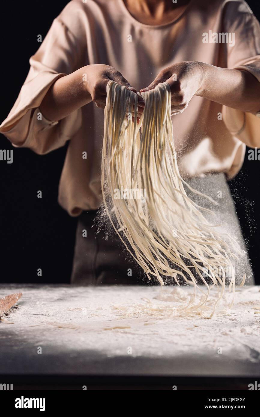 Shaking out the cut noodles, the process of making traditional Chinese ...